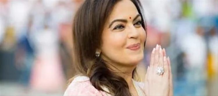 Nita Ambani MI jersey with YSL heels, carrying a bag worth